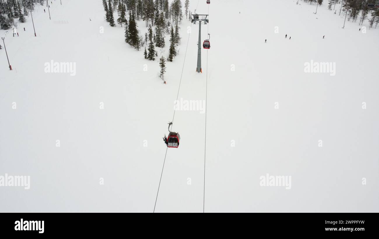 An aerial view of a snowy mountain landscape with a ski lift in Yllas ...