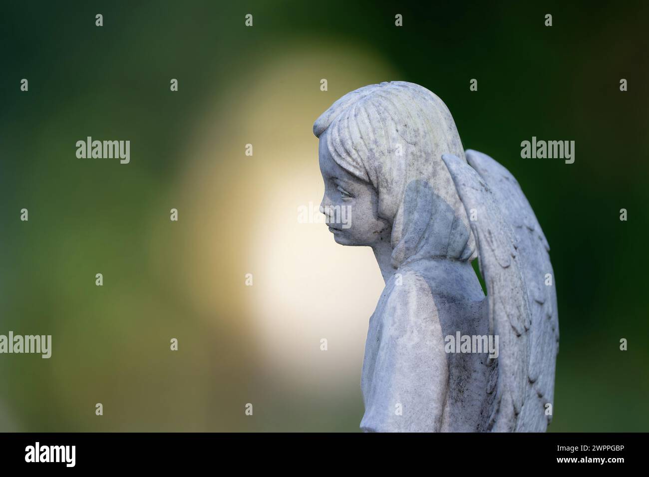 sad looking little angel figure on a gravestone in front of a beautiful ...