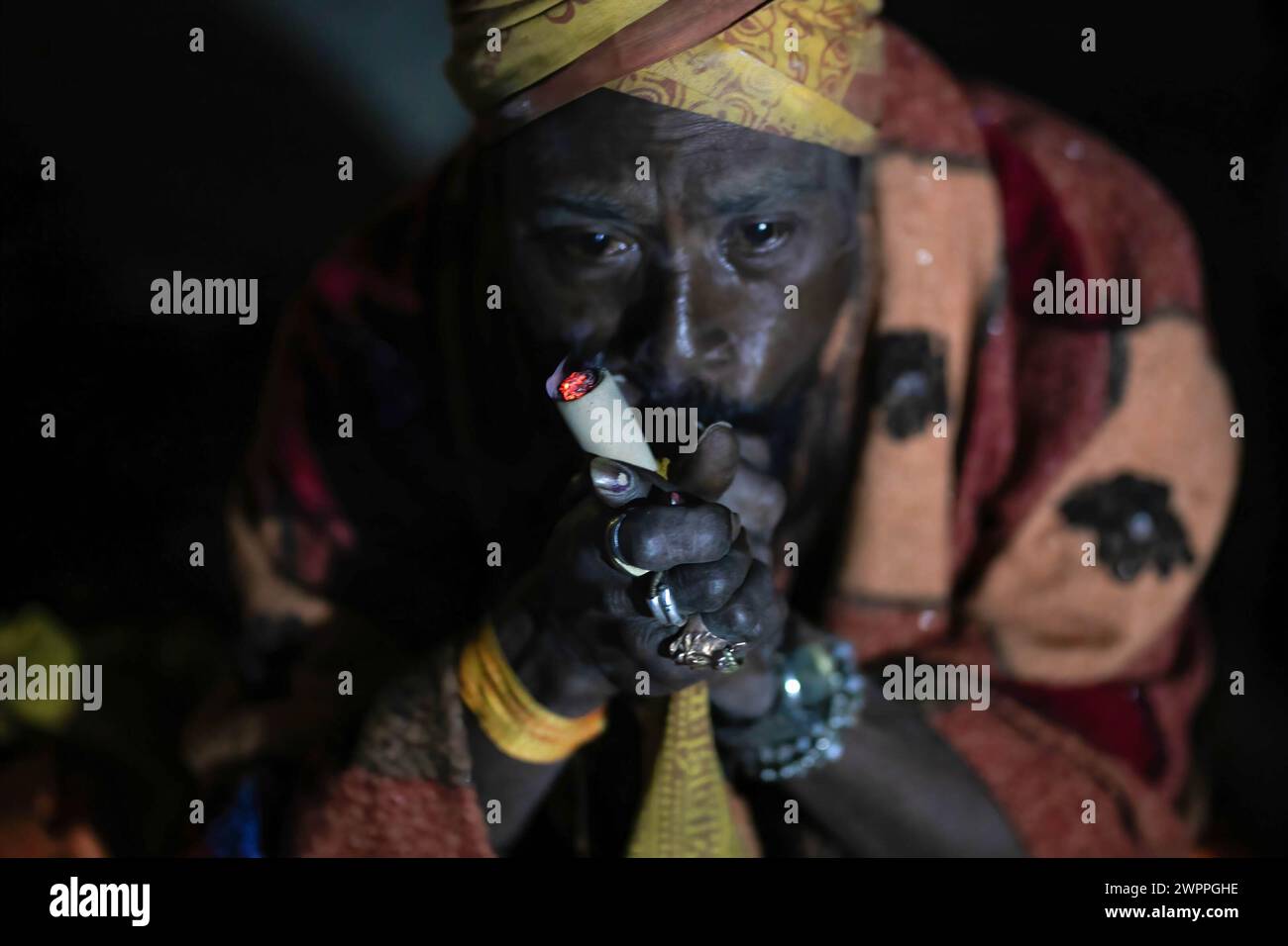 A Hindu holy man, or Sadhu, the follower of Lord Shiva, smokes ...