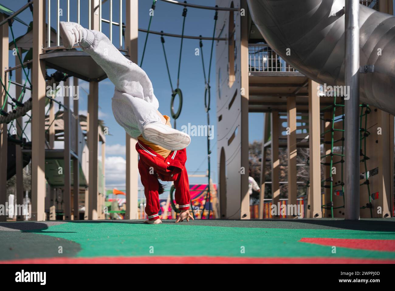 Child girl doing handstand on the outdoors playground. Funny active ...