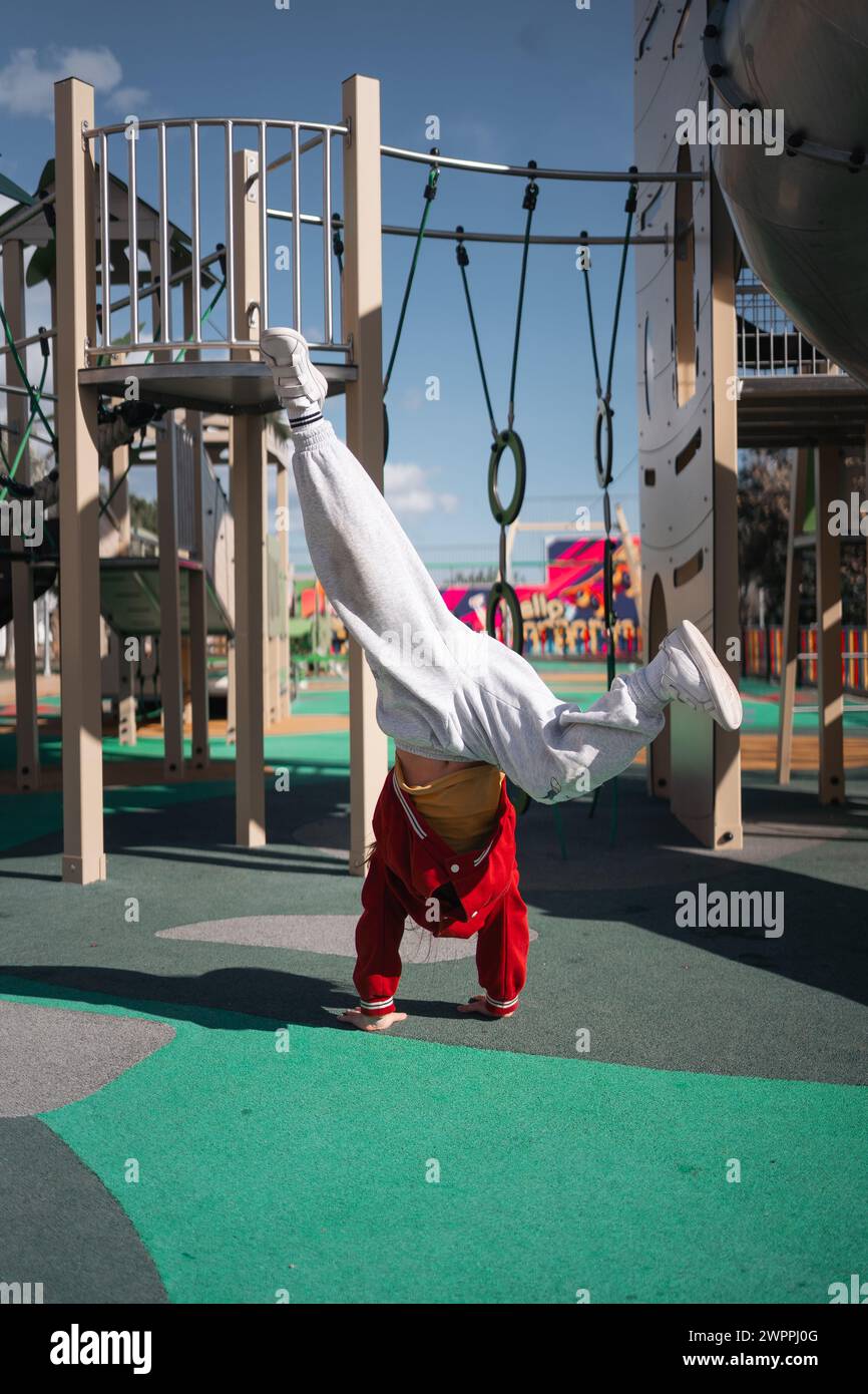 Child girl doing handstand on the outdoors playground. Funny active ...