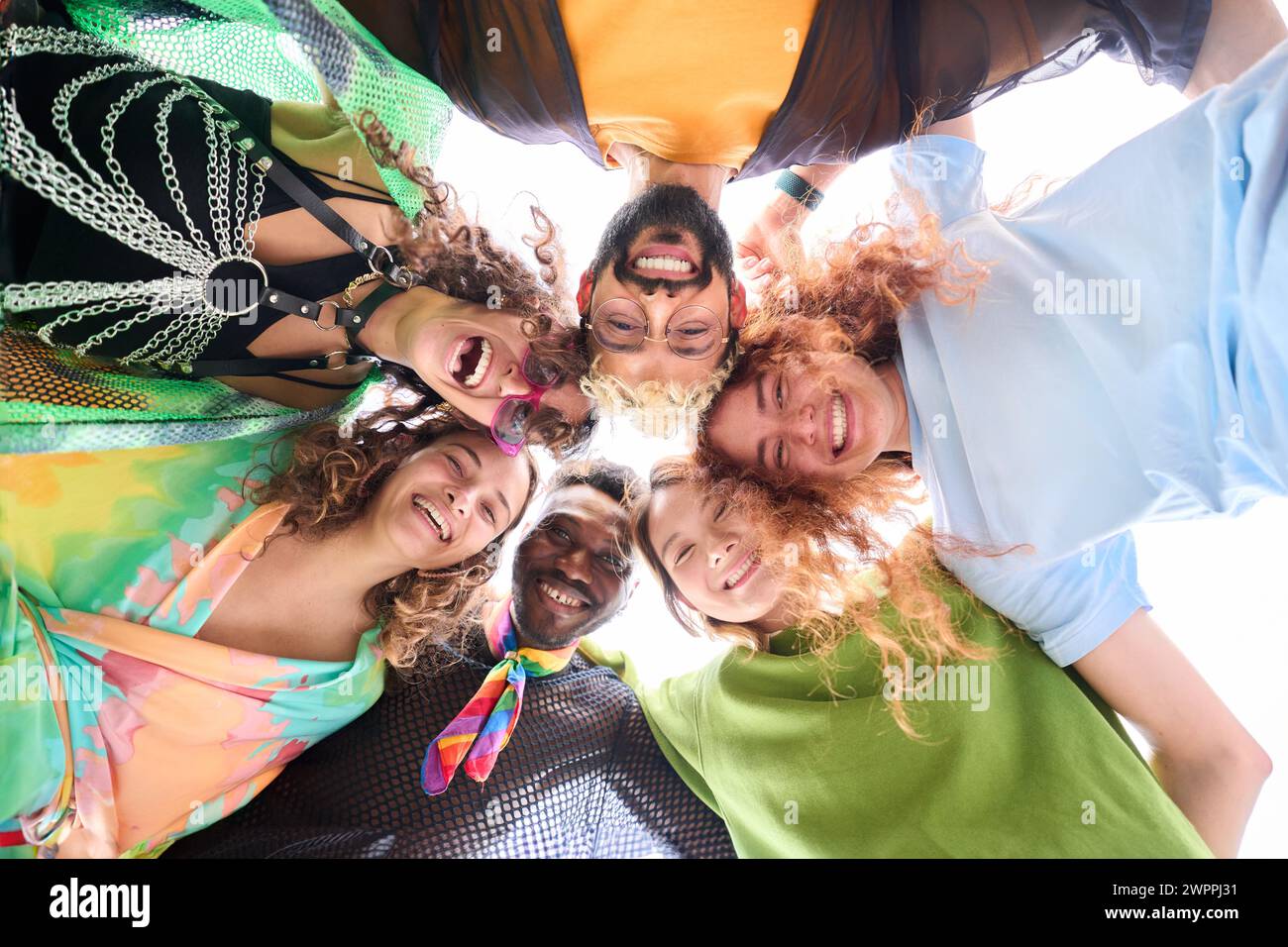 A group of people are standing in a circle with their heads together ...