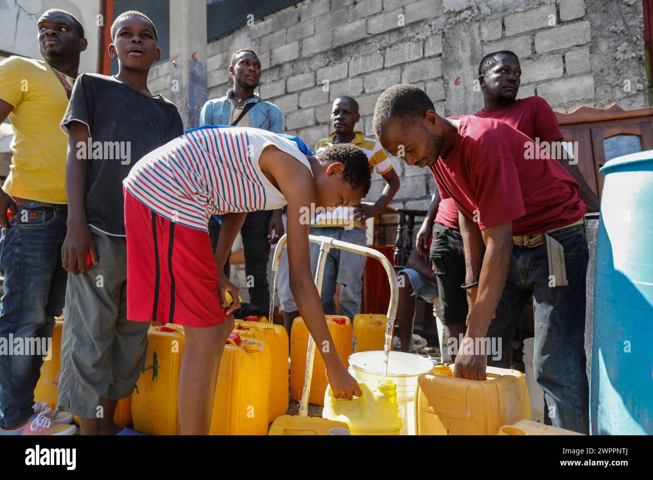 Residents fill their containers with potable water, in Port-au-Prince ...