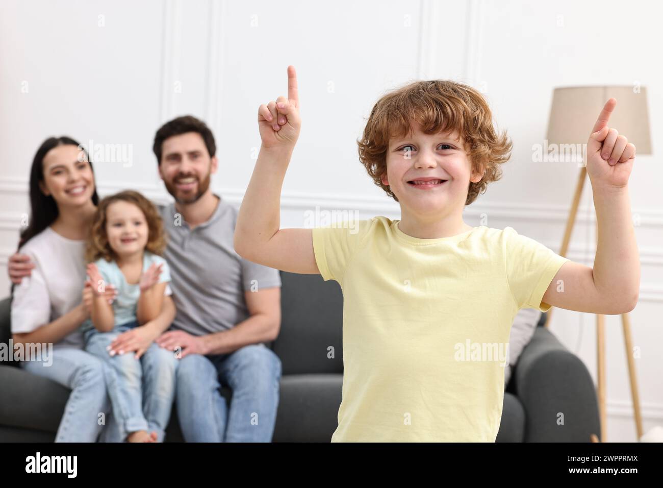 Happy family having fun at home. Son dancing while his relatives ...