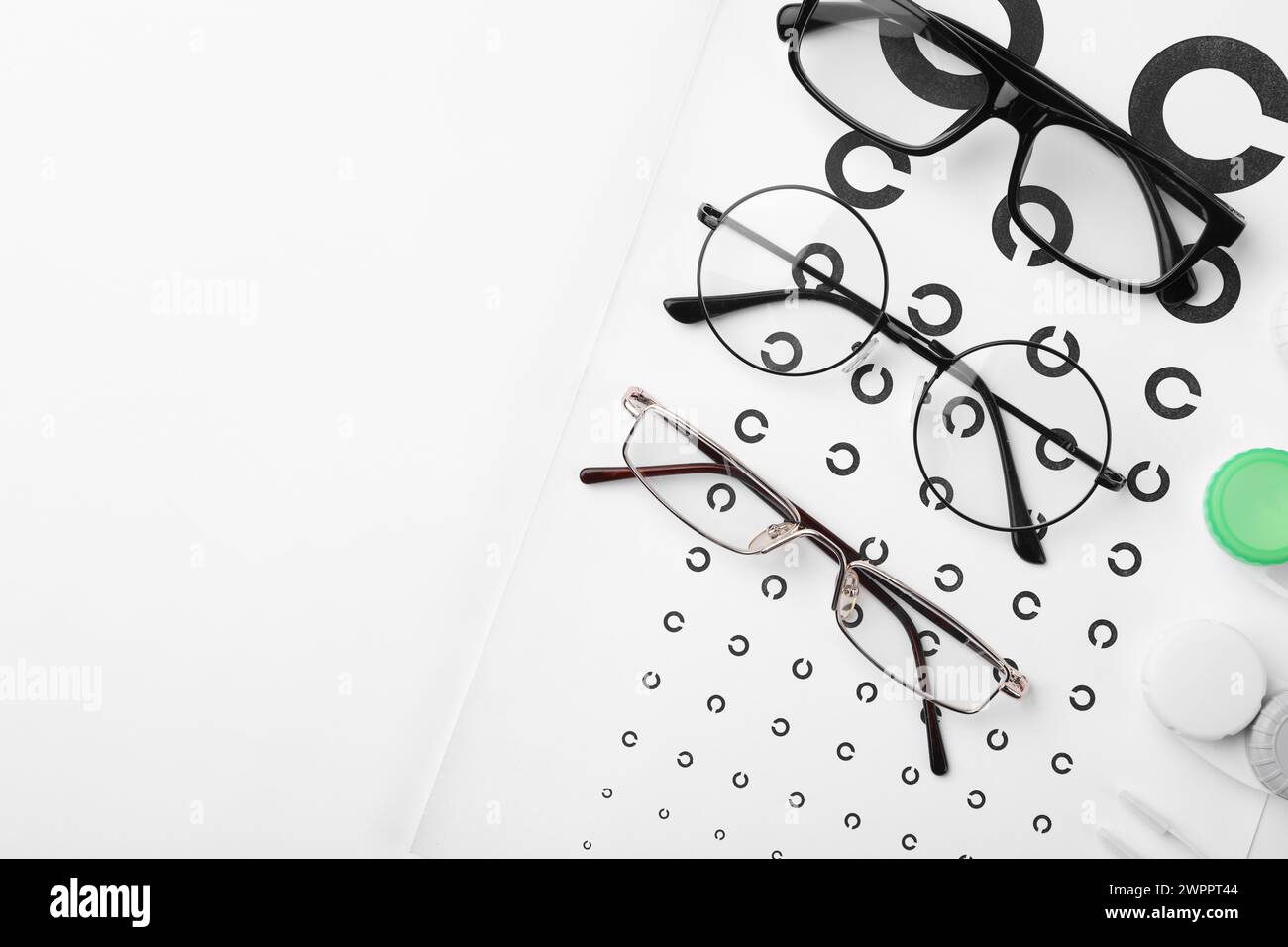 Vision test chart, glasses and lenses on white background, flat lay ...