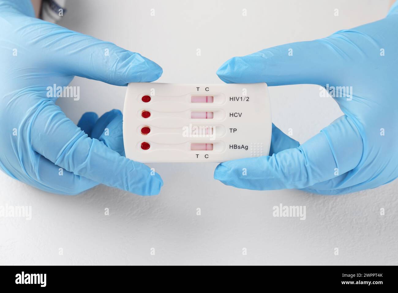 Doctor holding disposable multi-infection express test at white table ...