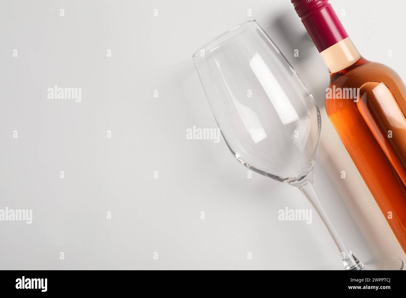 Bottle of expensive rose wine and wineglass on white background, top ...