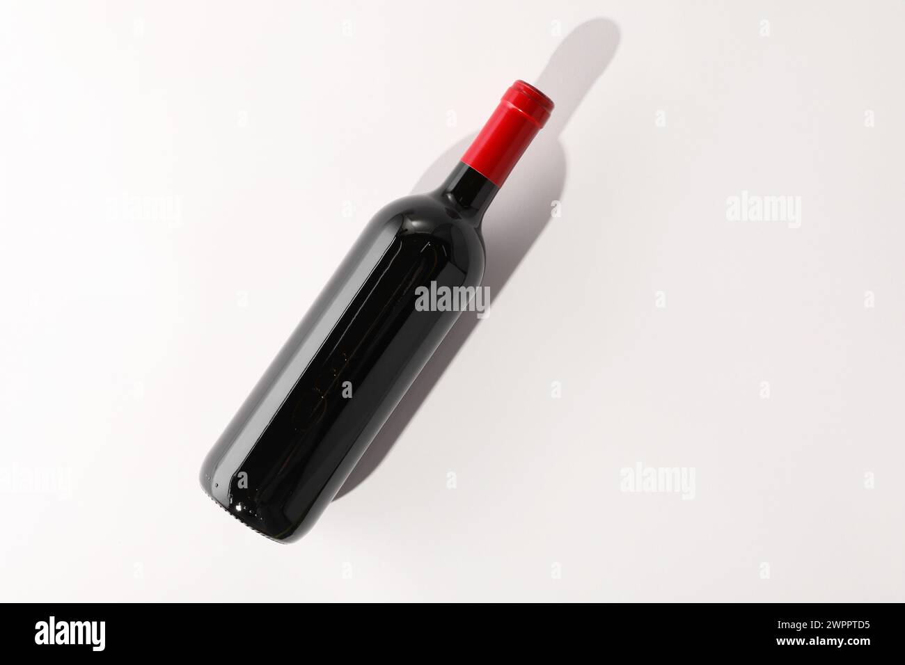 Bottle of expensive red wine on white background, top view. Space for ...