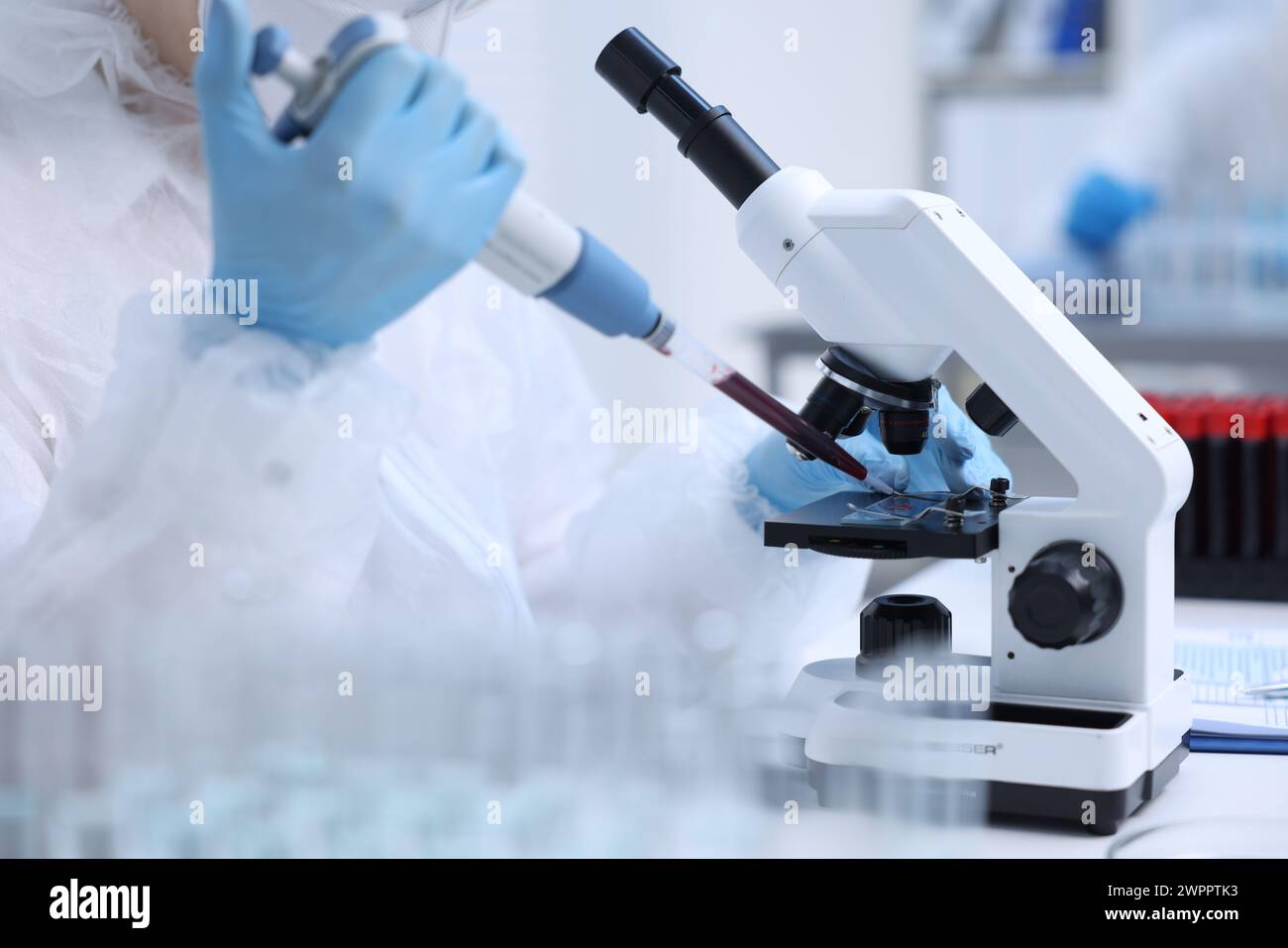 Scientist dripping sample onto glass slide while working with ...