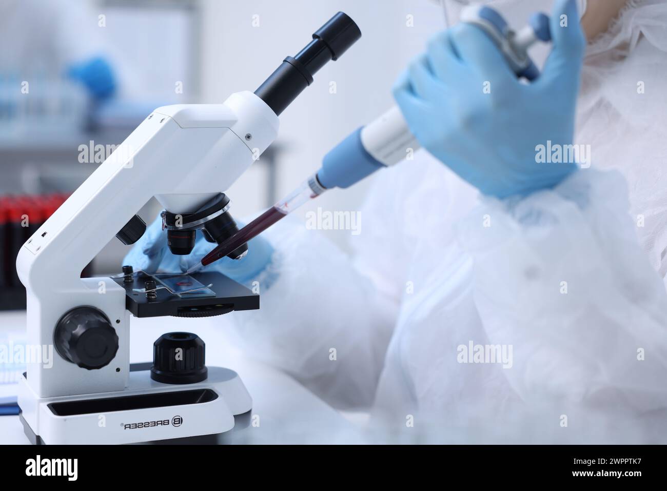 Scientist dripping sample onto glass slide while working with ...