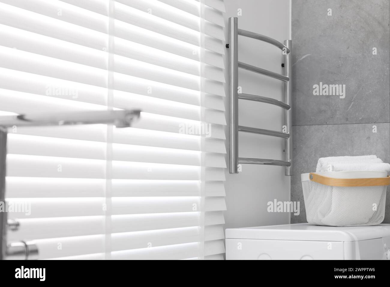 Modern heated towel rail on wall in bathroom Stock Photo - Alamy