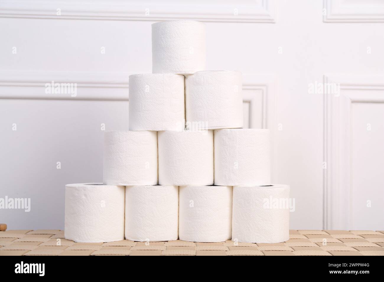 Pyramid of toilet paper rolls on wicker table Stock Photo - Alamy