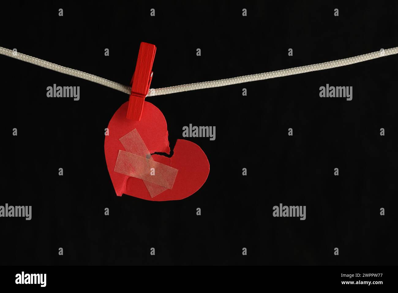 Broken heart. Torn red paper heart with medical adhesive bandages on ...