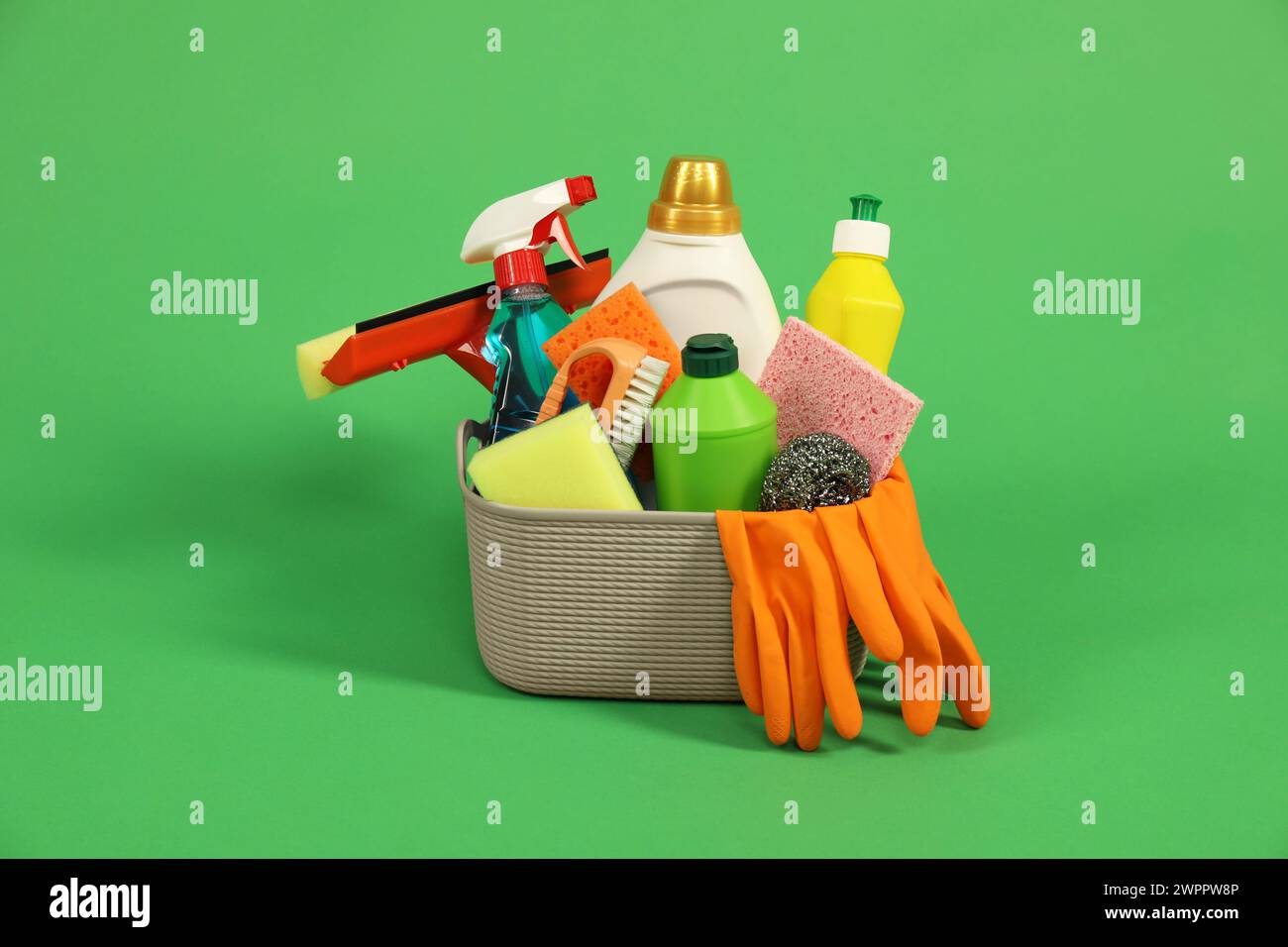 Different cleaning products in basket on green background Stock Photo ...