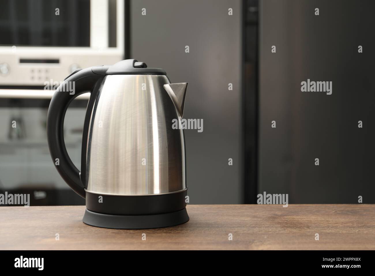 Modern electric kettle on table in kitchen. Space for text Stock Photo ...