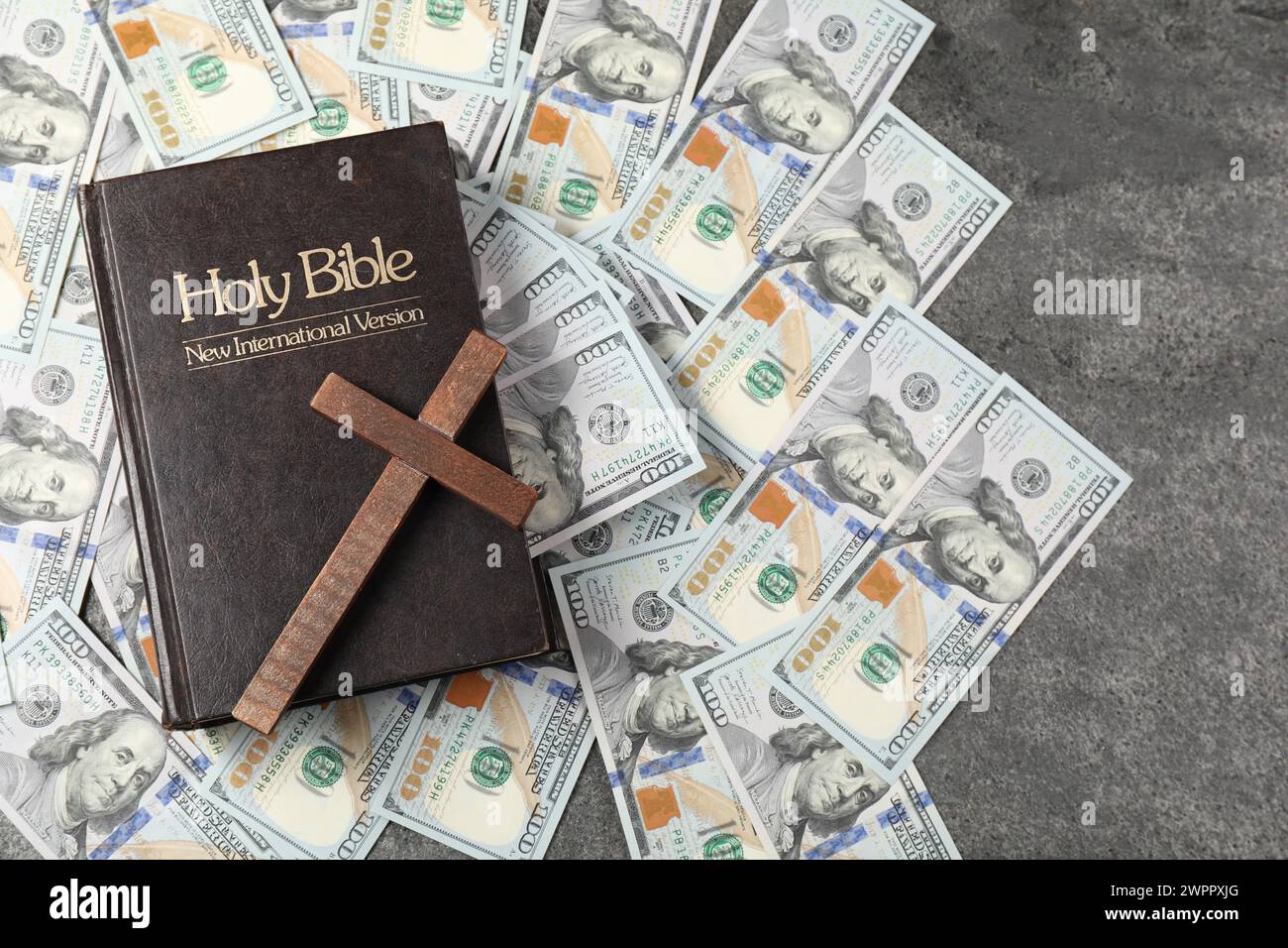 Holy Bible, cross and money on grey table, top view Stock Photo - Alamy