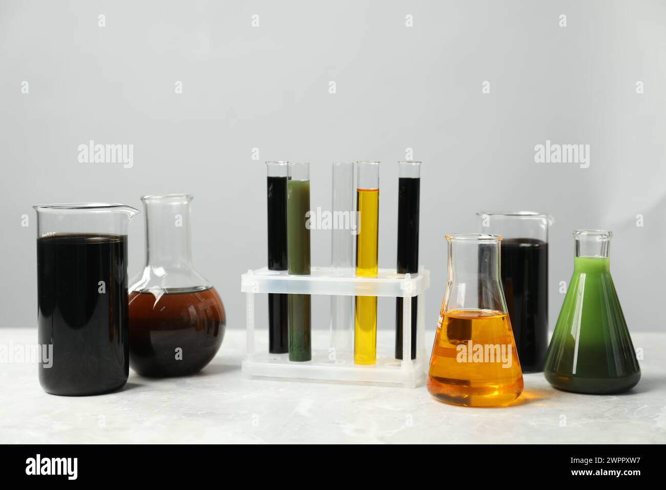 Laboratory glassware with different types of oil on white table Stock ...