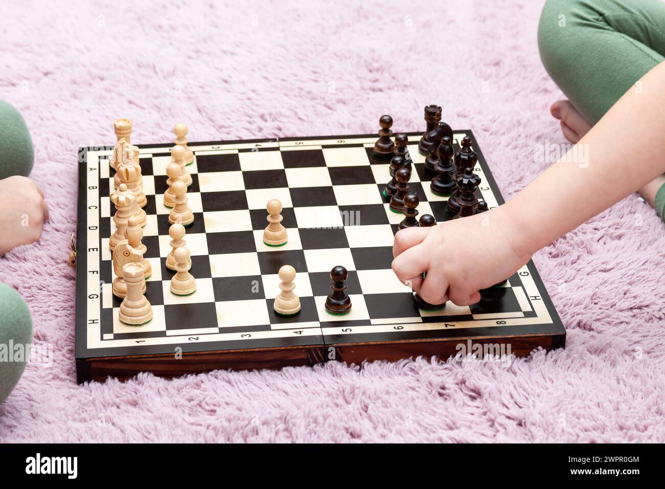 Close-up view capturing a young childs hand moving a chess piece during ...