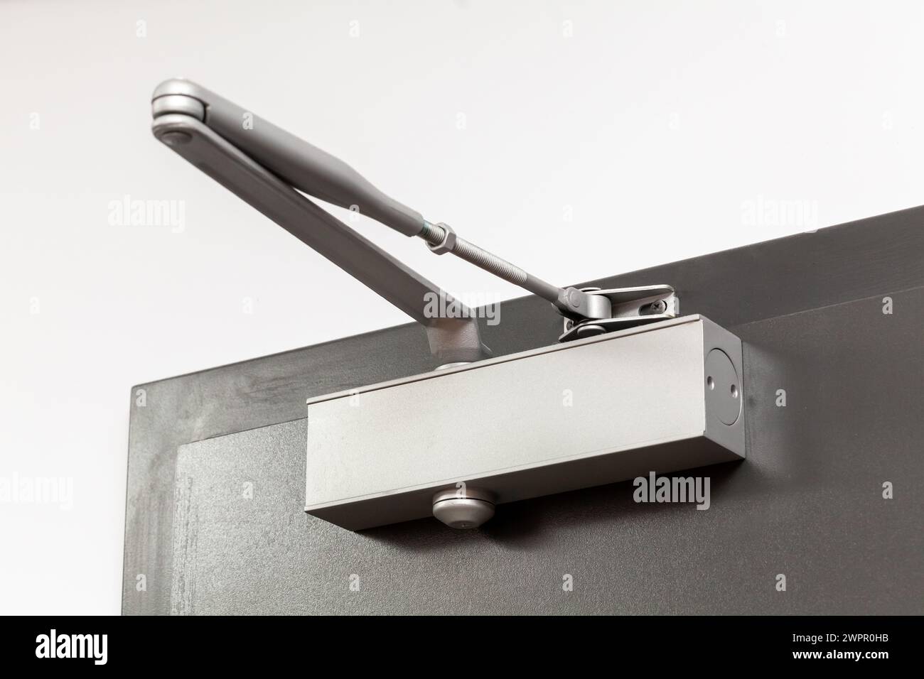 Close-up showing a modern silver door closer mechanism, with its ...