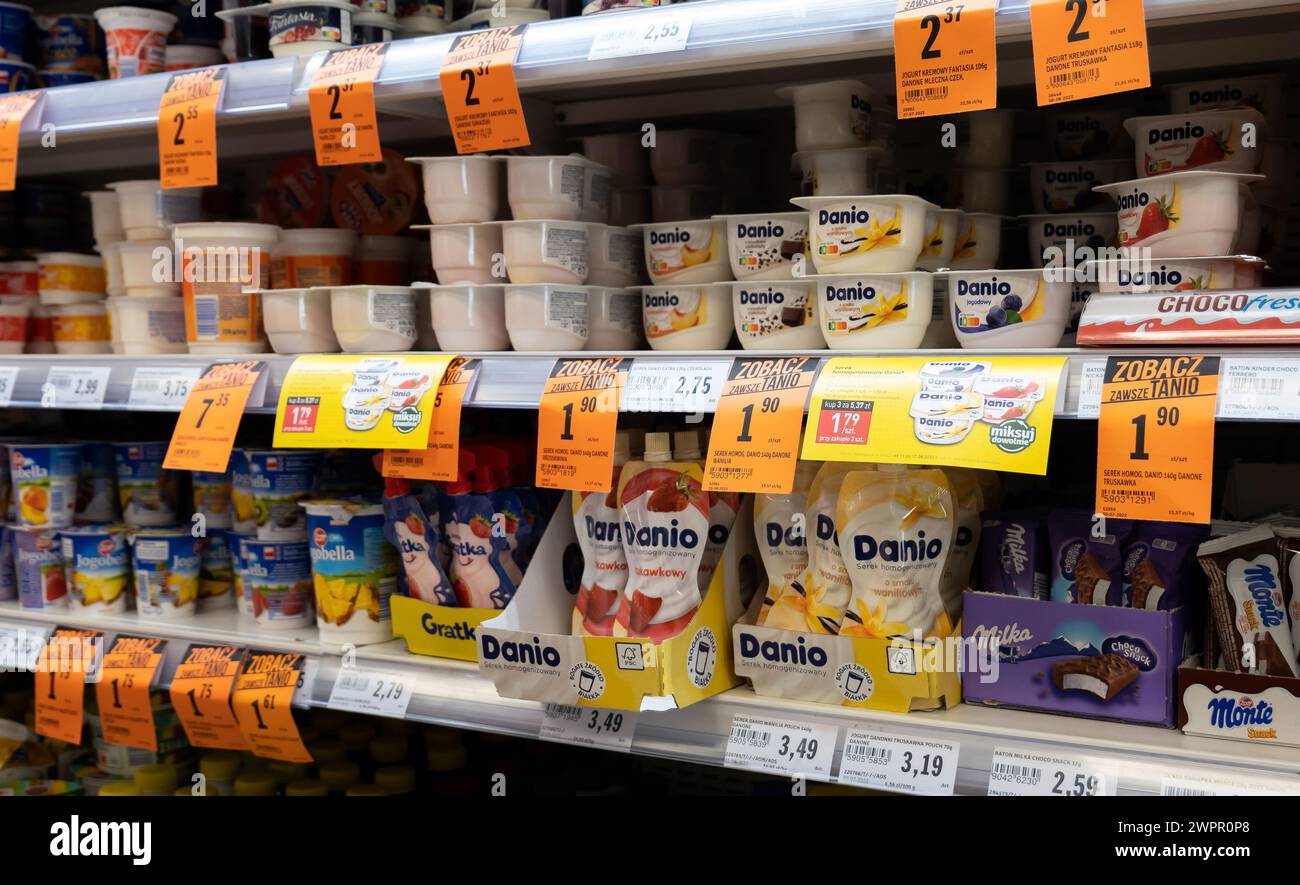 Shelves stocked with assorted dairy items, including yogurts arranged ...