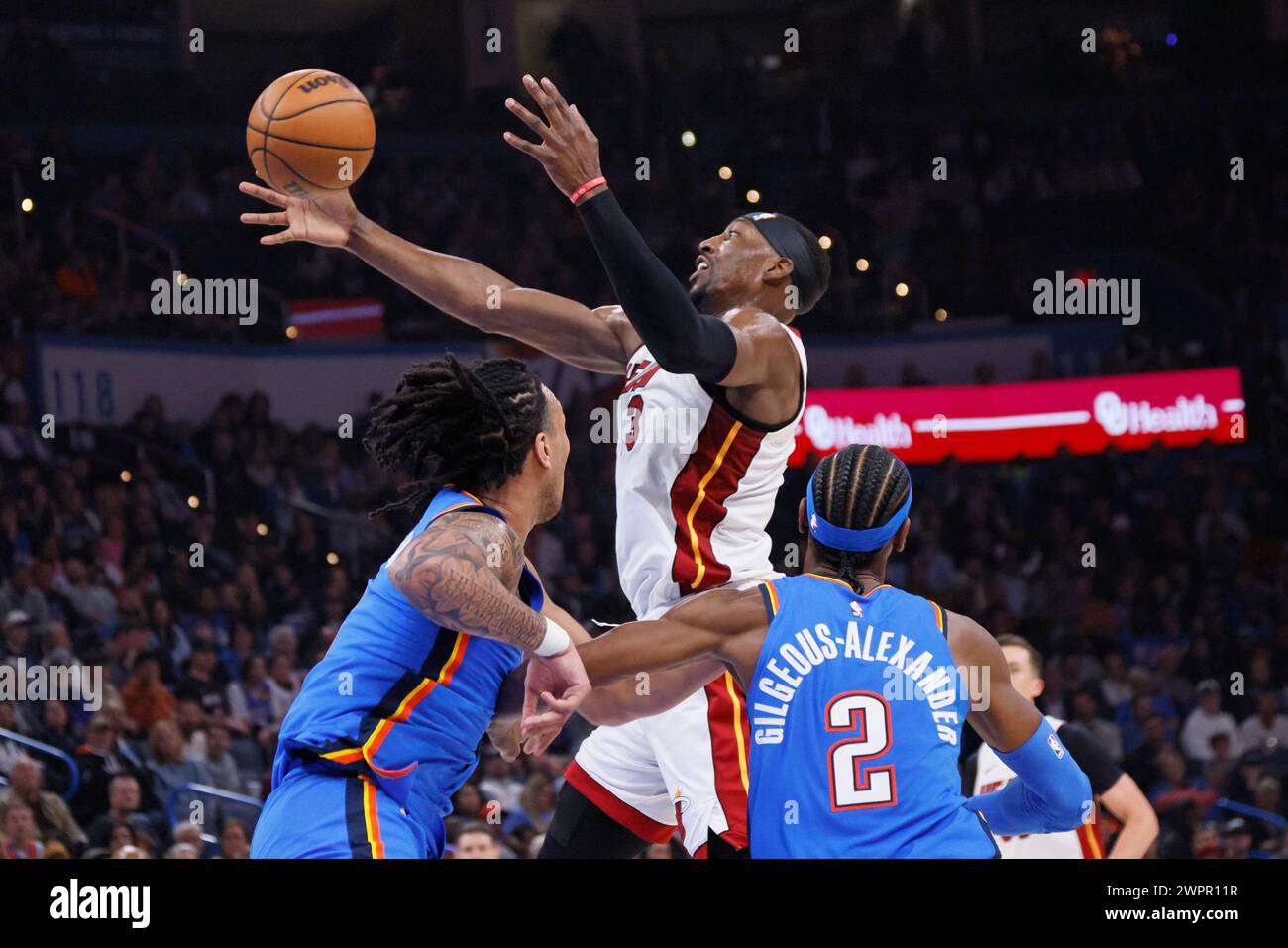 Miami Heat center Bam Adebayo, center, tries to catch the ball near Oklahoma City Thunder ...