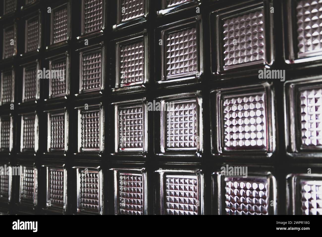Close-up perspective of a repetitive pattern of square textured glass ...