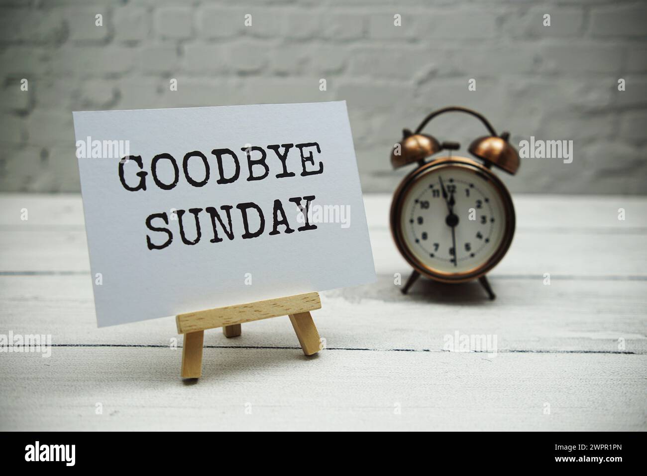 Goodbye Sunday with alarm clock on white brick wall and wooden ...
