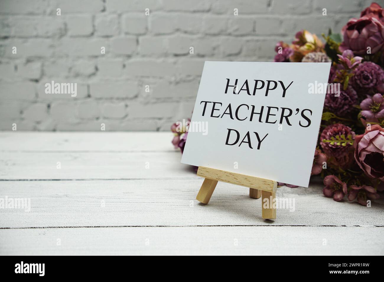 Happy Teachers Day text on white brick wall and wooden background Stock ...