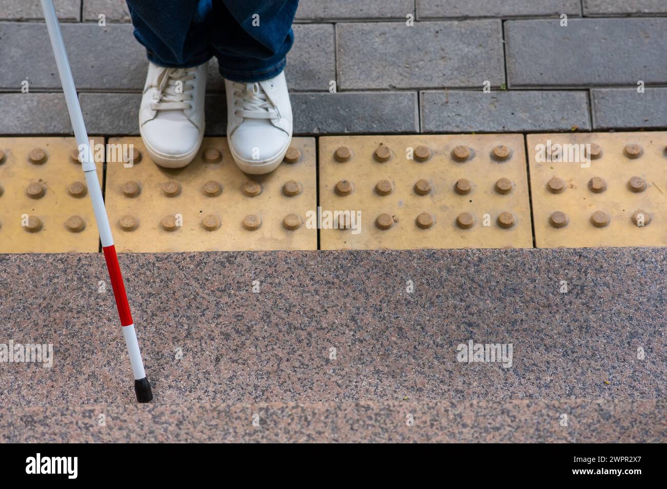 Blind woman walking outdoors using a tactile cane Stock Photo - Alamy
