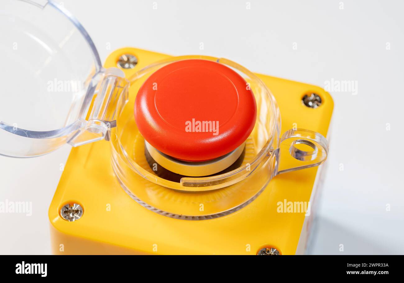 Close-up shot of a red emergency stop button with a protective clear ...