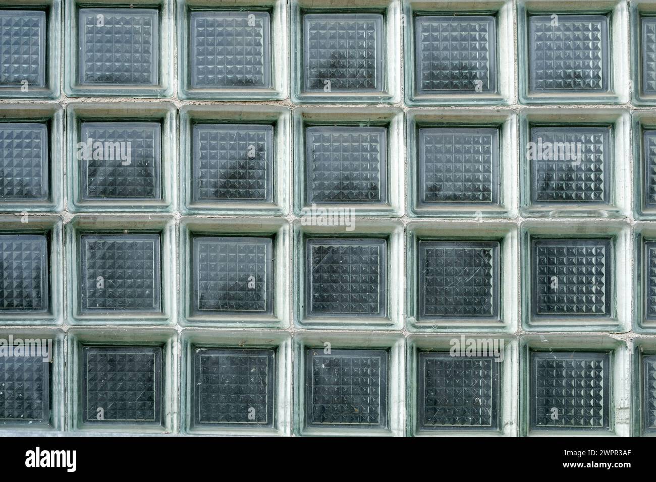 Close-up view of a symmetrical and textured glass block wall, old 80s ...