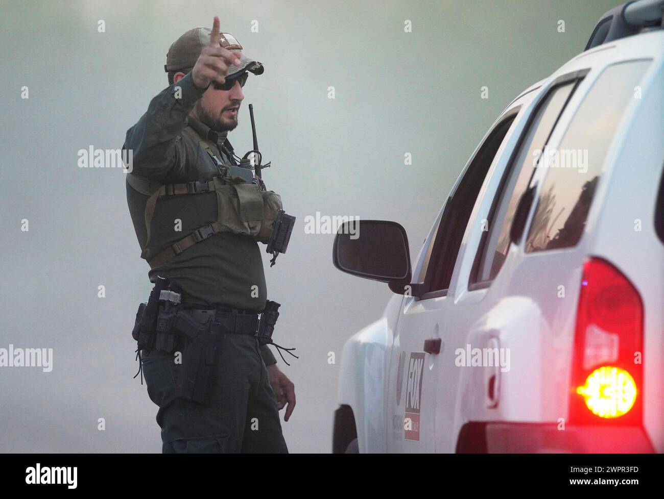 A U.S. Customs and Border Protections agent divert members of the media ...