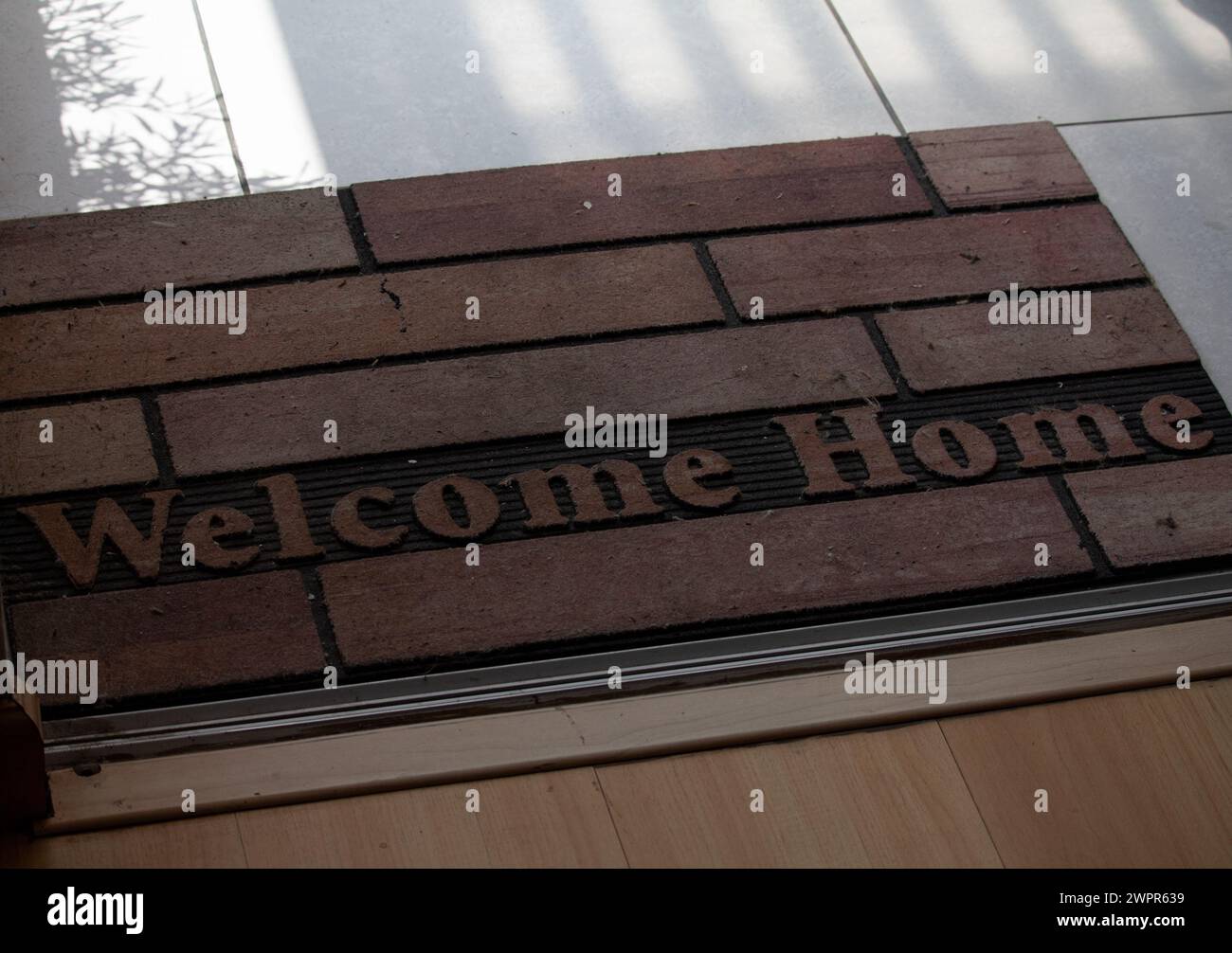 Brown Welcome home floormat Stock Photo - Alamy