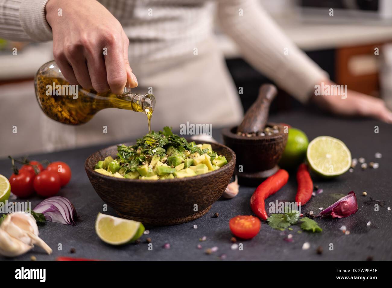 Cooking traditional salsa - woman pours olive oil into bowl with sliced ...