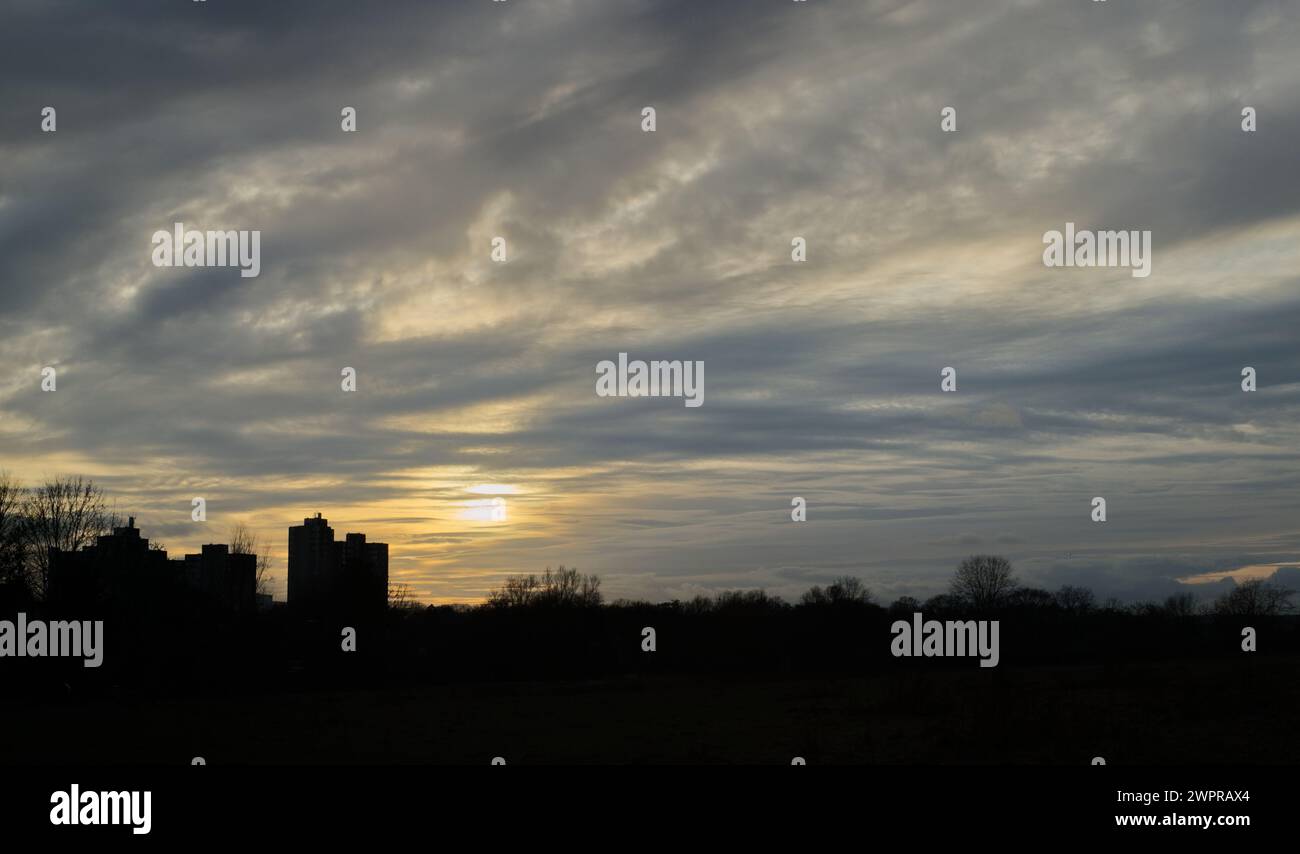 A calm evening sky and the city skyline with silhouettes of some ...