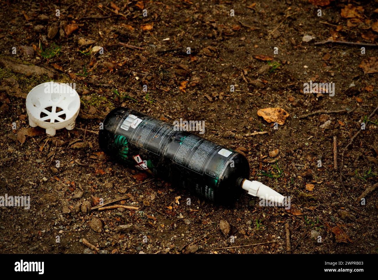 Empty black nitrous oxide gas cartridge on the ground discarded by a ...