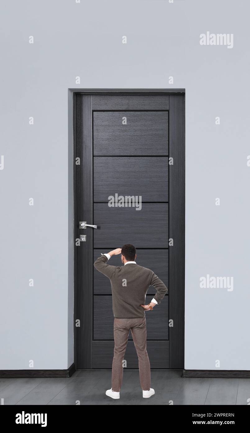 Man standing in front of door, back view Stock Photo - Alamy
