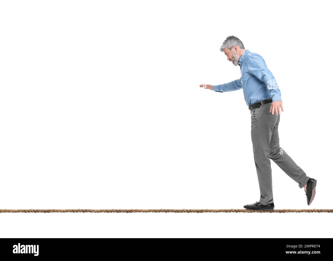 Risks and challenges of owning business. Man balancing on rope against ...