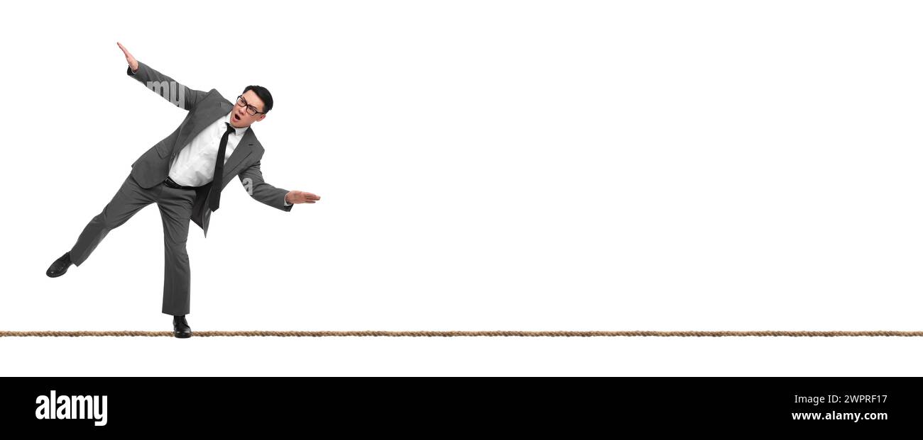 Risks and challenges of owning business. Man balancing on rope against ...