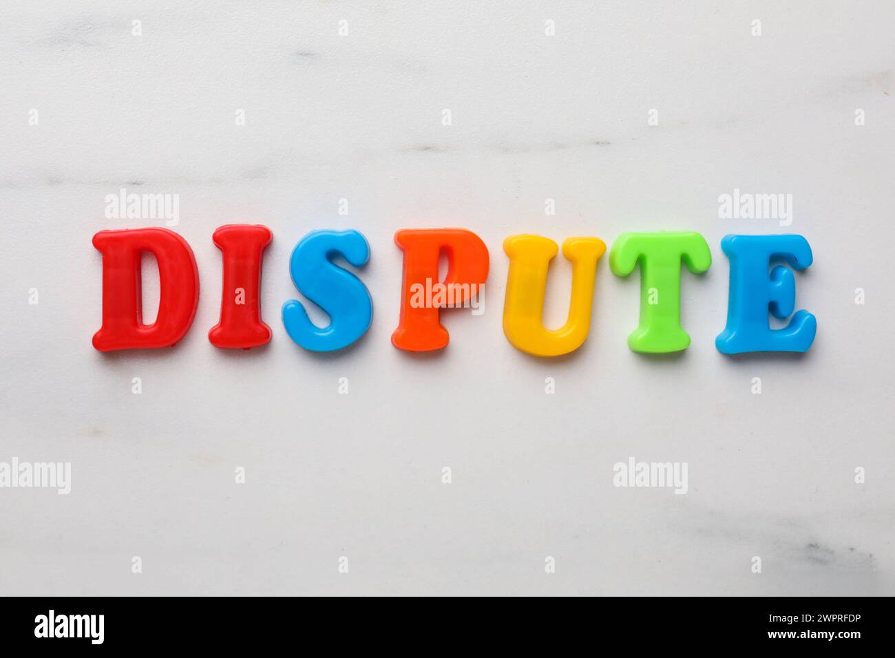 Word Dispute made of colorful letters on white marble table, flat lay ...