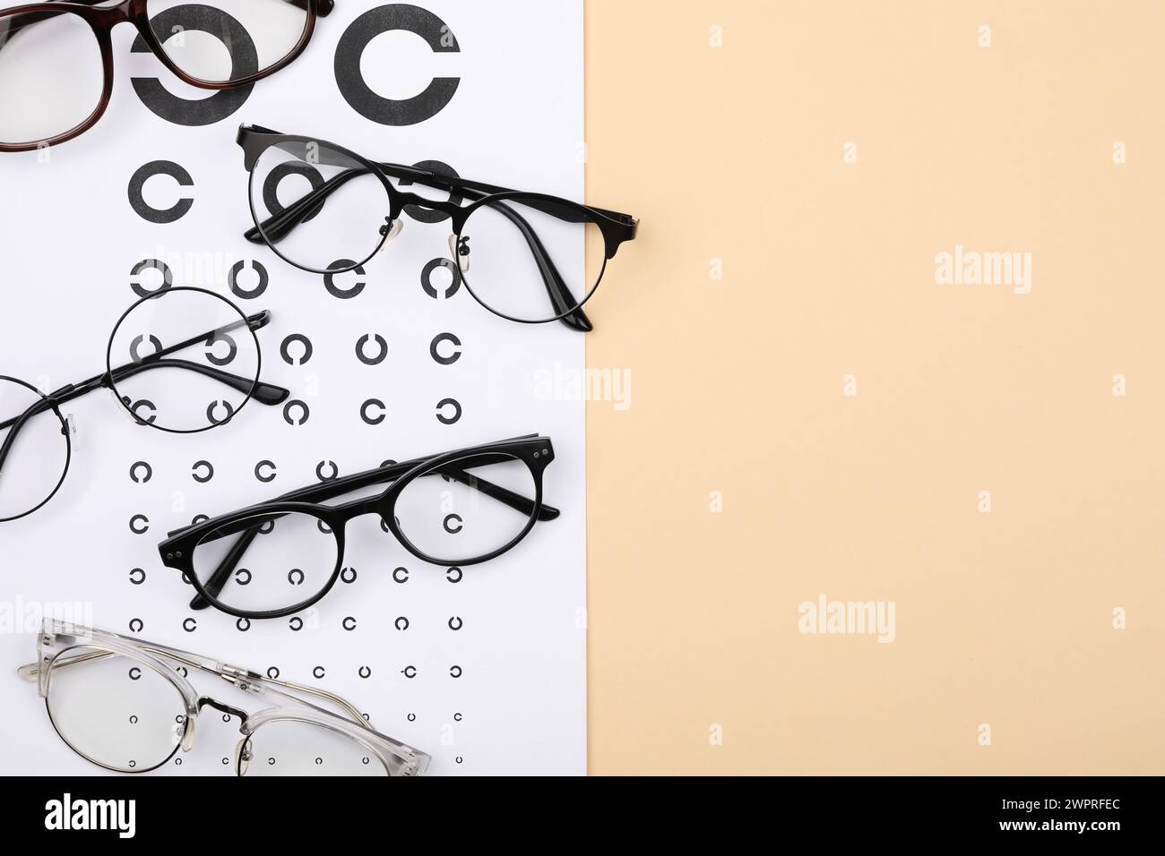 Vision test chart and glasses on beige background, flat lay. Space for ...