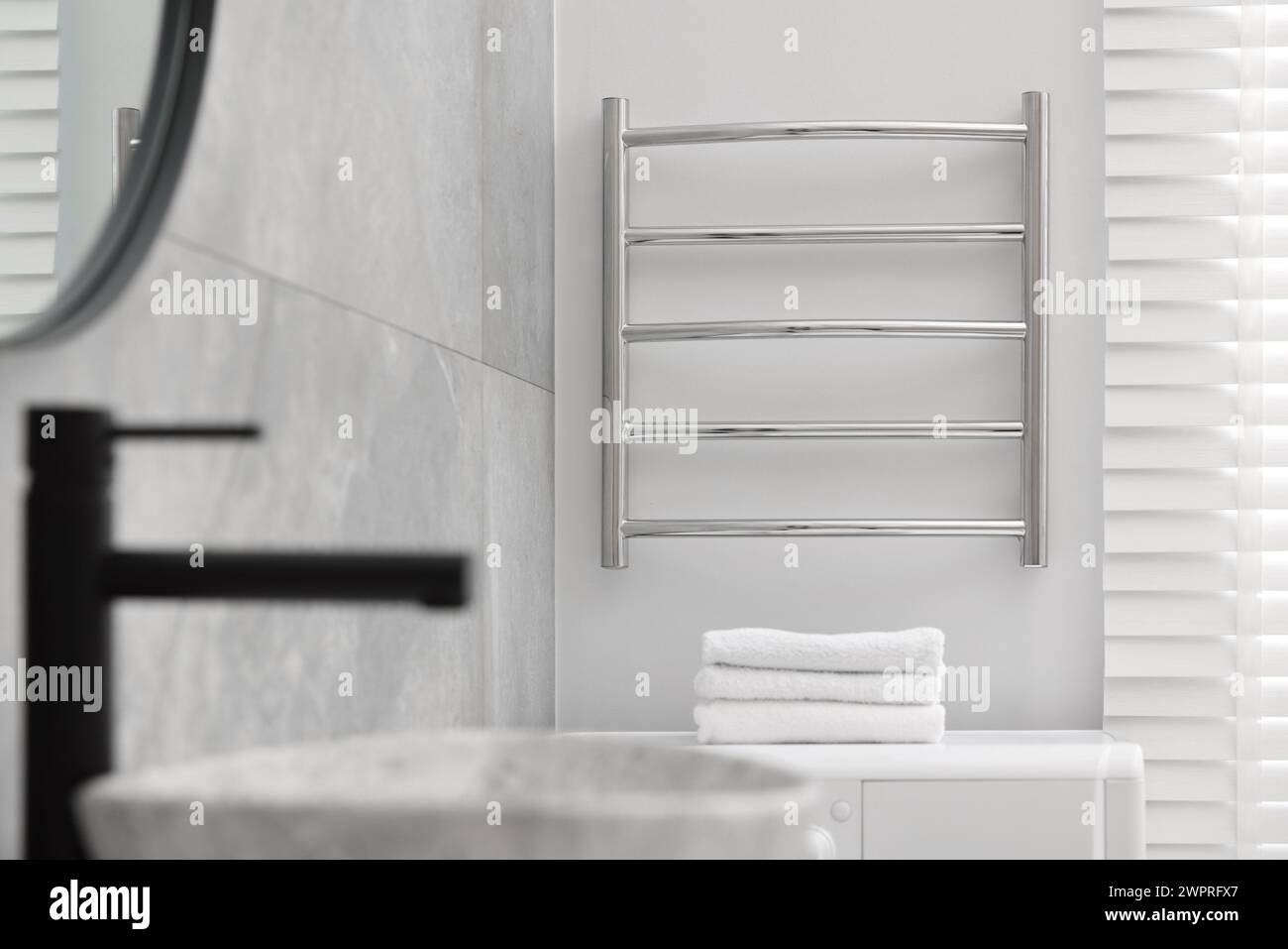 Modern heated towel rail on wall in bathroom Stock Photo - Alamy