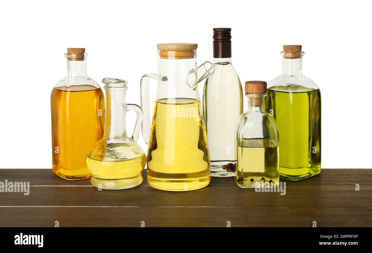 Vegetable fats. Different cooking oils on wooden table against white ...