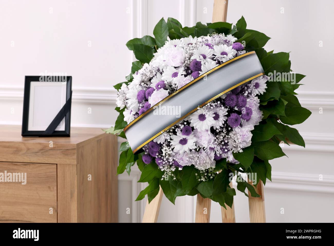 Wreath of violet and white flowers, photo frame with black ribbon in ...