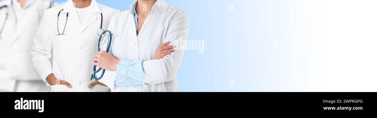 Doctors and nurse on light blue background, closeup. Banner design with ...