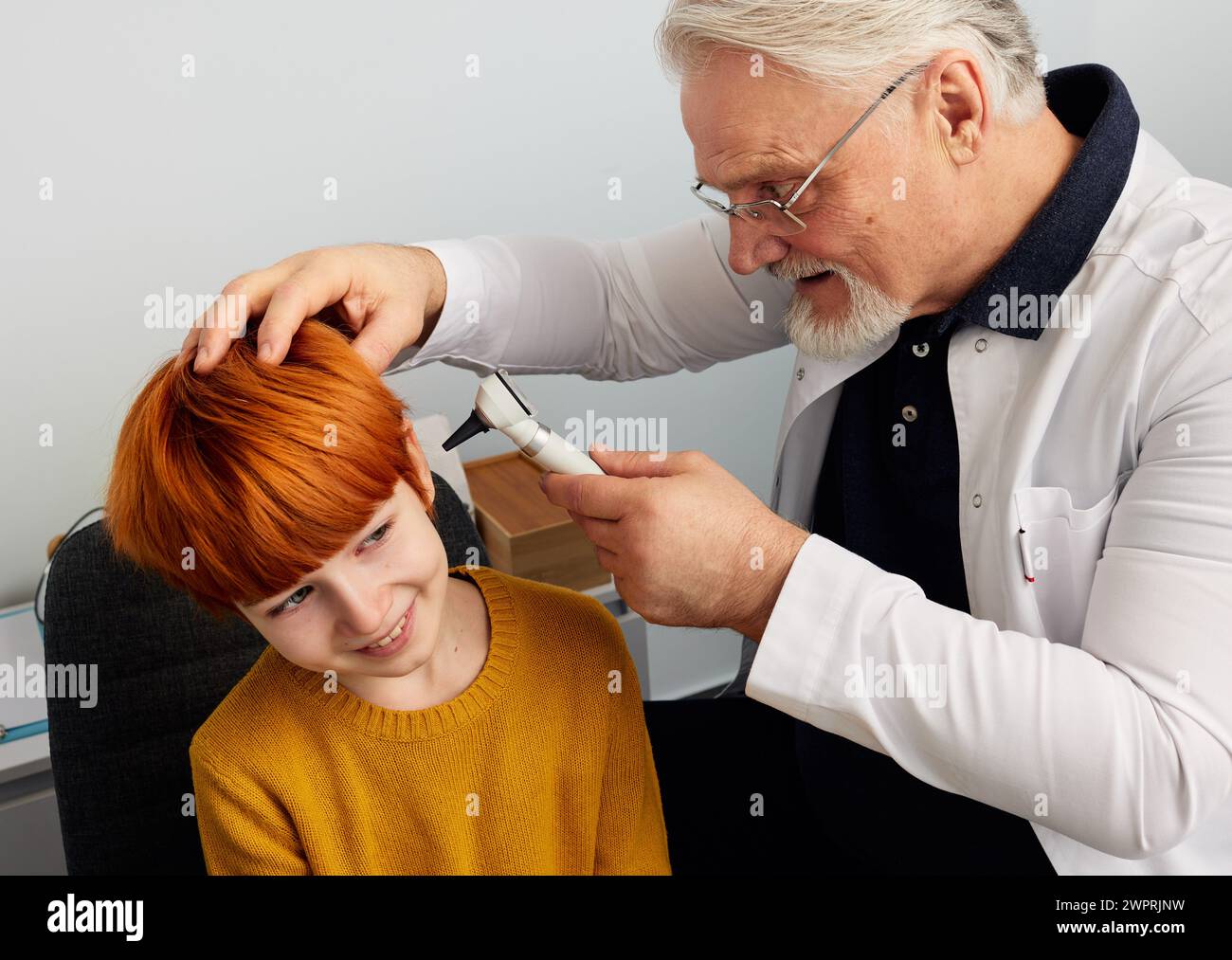 Positive red-haired male child during ear examining at hearing clinic ...