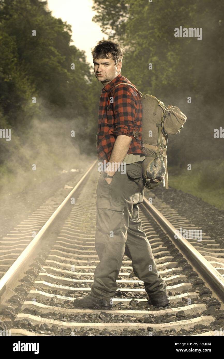 Adventurer with retro haversack wandering nature on railroad way Stock ...