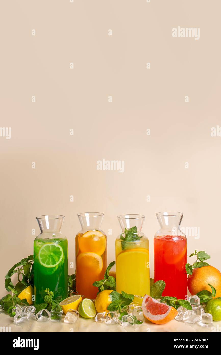 Assorted cold lemonades in glass jugs on an ochre background. photos ...