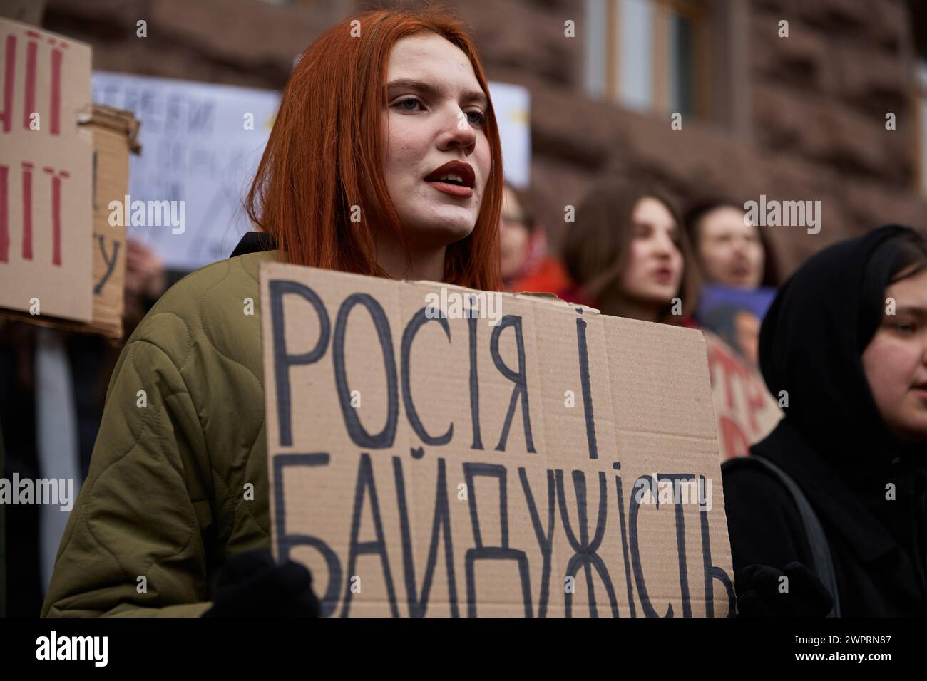Ukrainian activist holds a banner " russia and indifference" on a ...