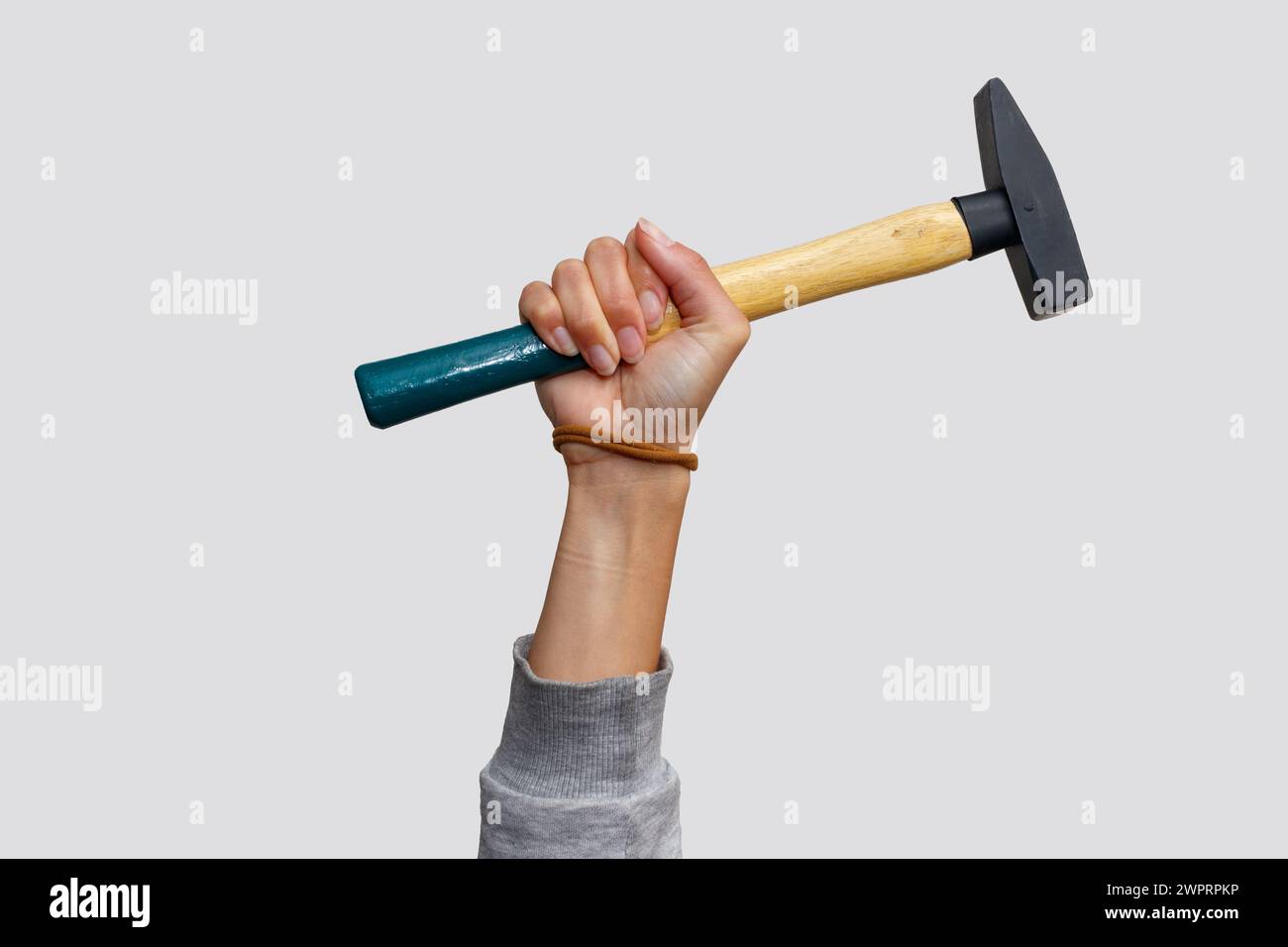 Woman's hand holdin a hammer on an isolated white background. Showing ...